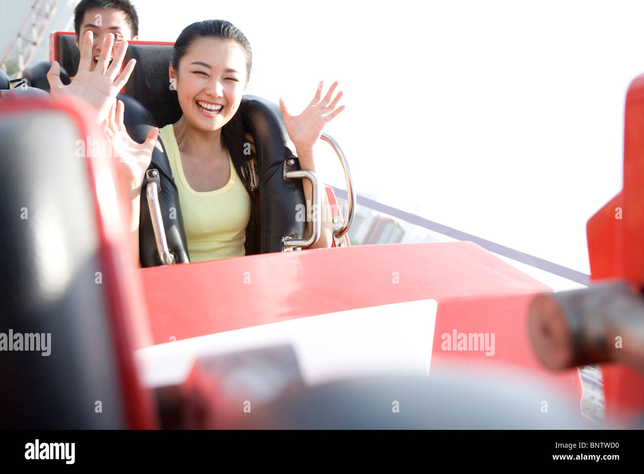 Young people riding a rollercoaster Stock Photo - Alamy