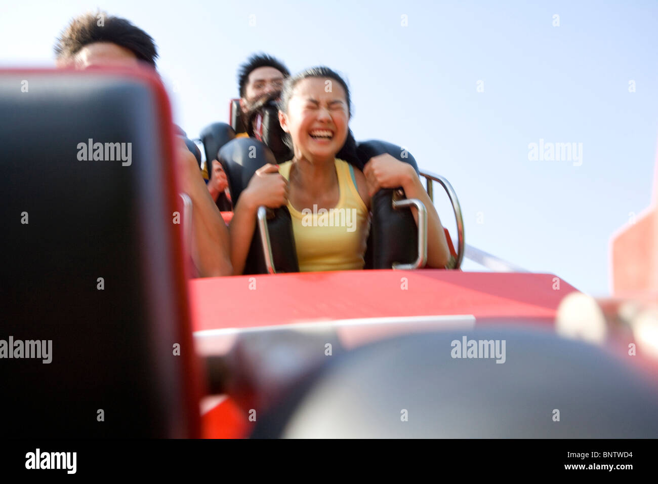 Young people riding a rollercoaster Stock Photo - Alamy