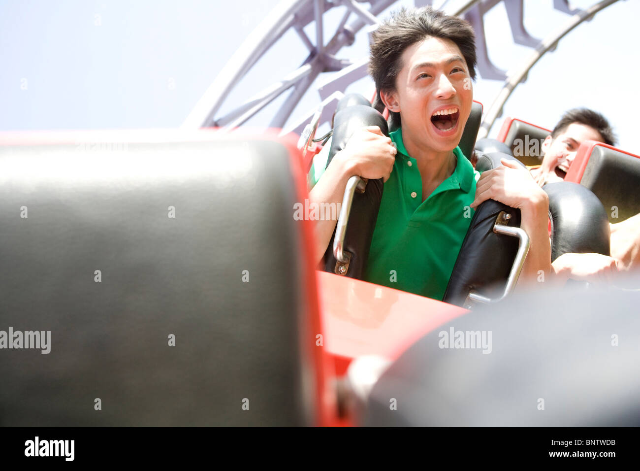 Young people riding a rollercoaster Stock Photo - Alamy