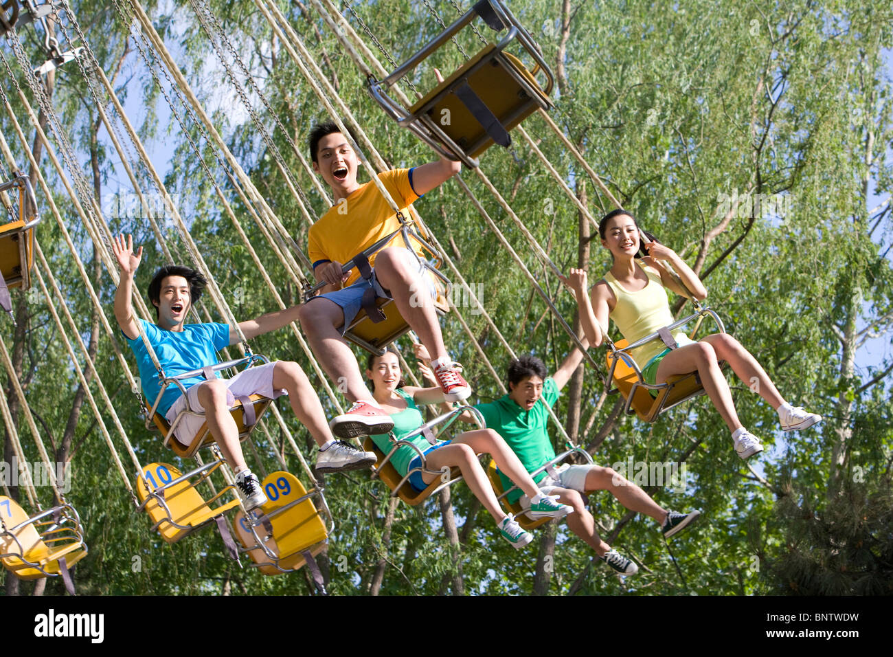Young people having fun at the amusement park Stock Photo - Alamy