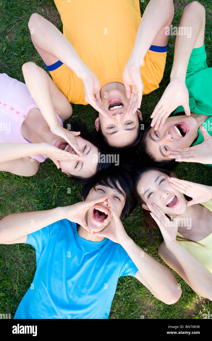 A group of young people shouting in a circle Stock Photo - Alamy