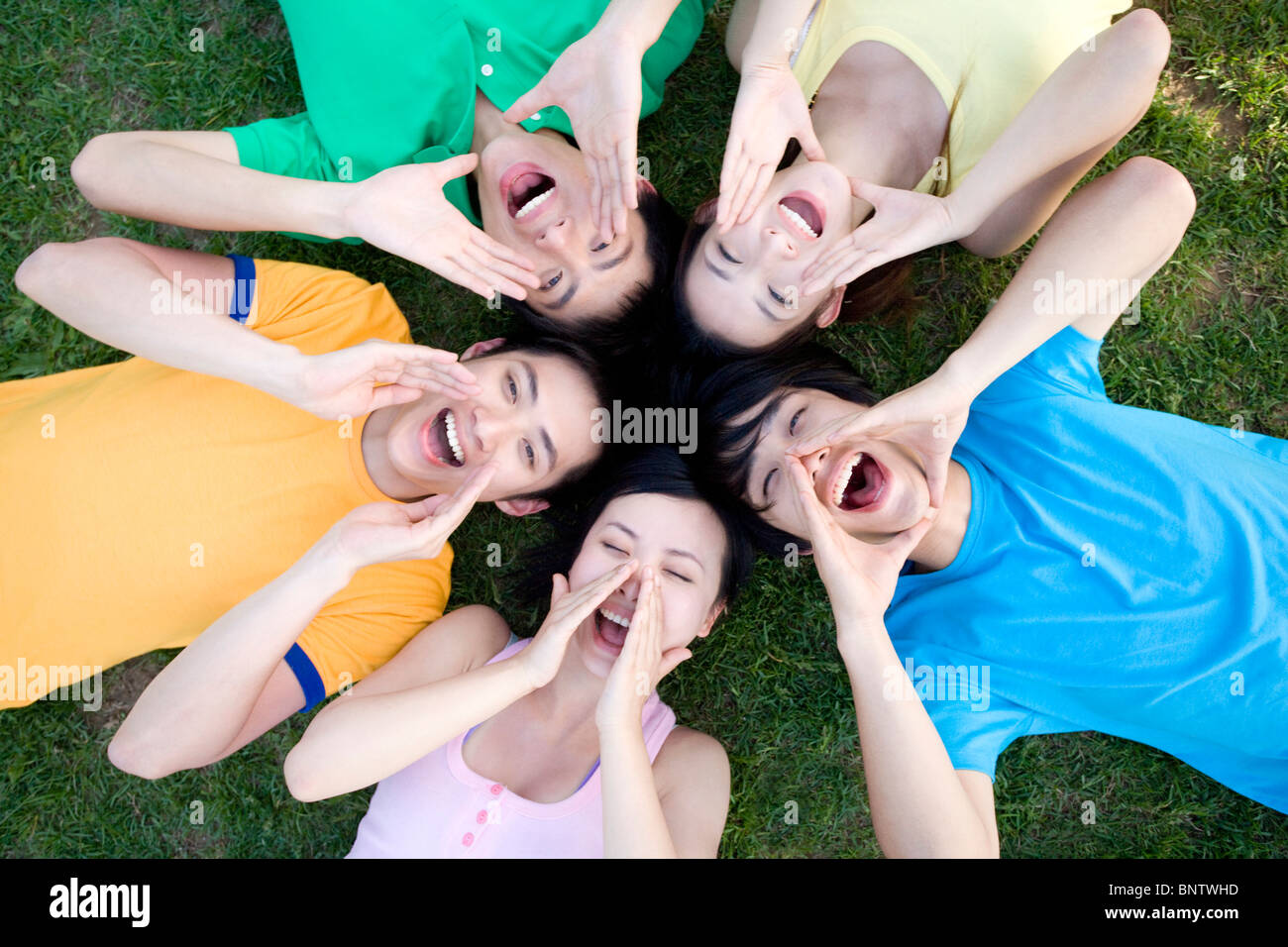 A group of young people shouting in a circle Stock Photo - Alamy
