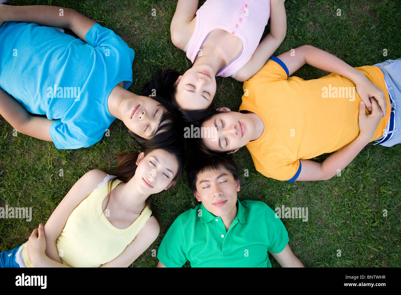A group of young people napping in a circle Stock Photo - Alamy