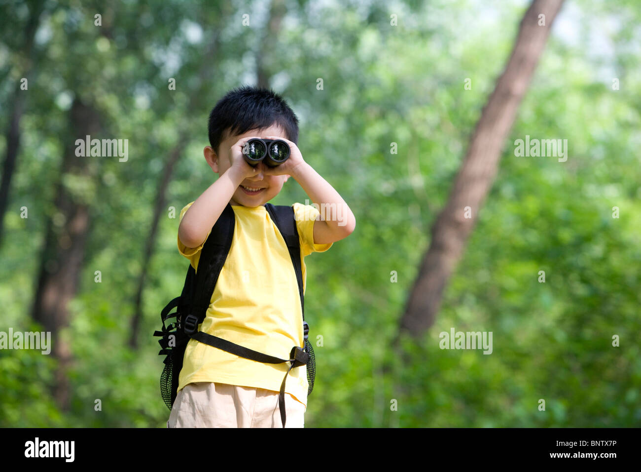 Young boy looking through binoculars Stock Photo - Alamy