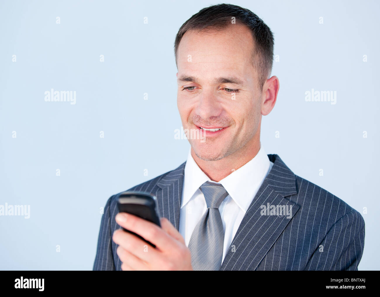 Handsome businessman sending a text with his phone Stock Photo - Alamy
