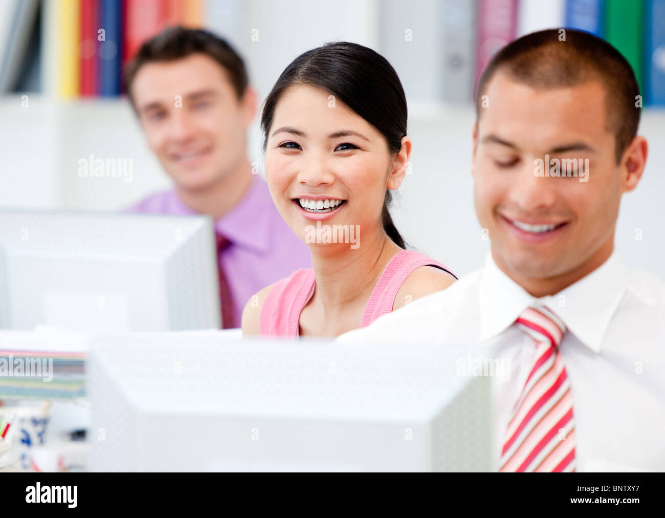 Happy business people working at a computer Stock Photo - Alamy