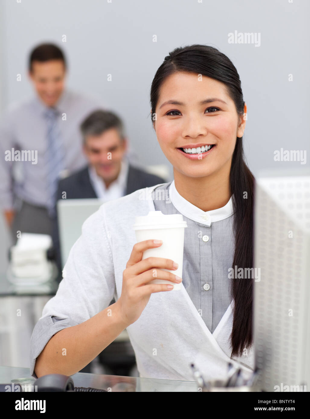Woman drinking coffee in the office Stock Photo - Alamy
