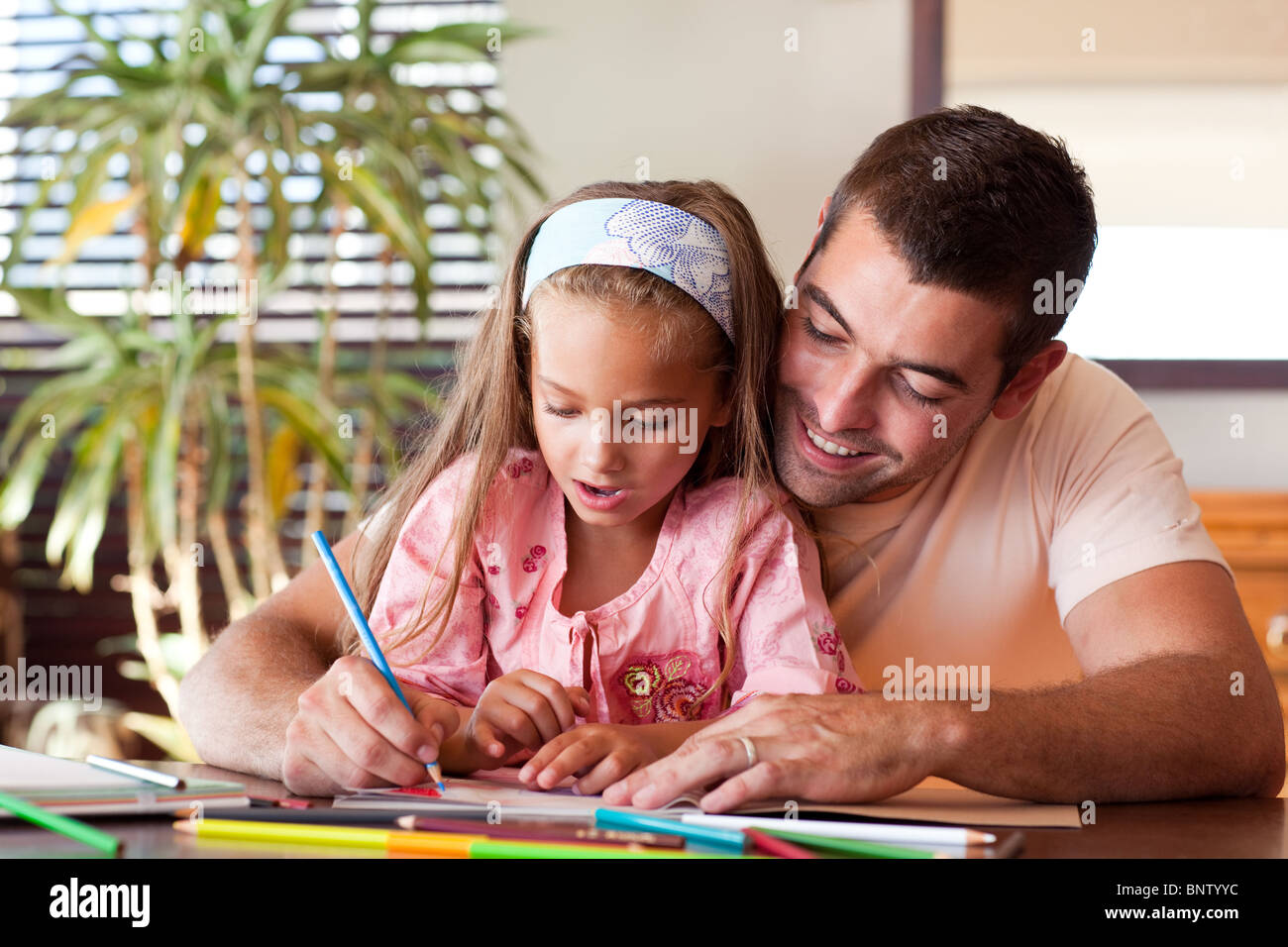 Radiant father helping her daughter for homework Stock Photo - Alamy