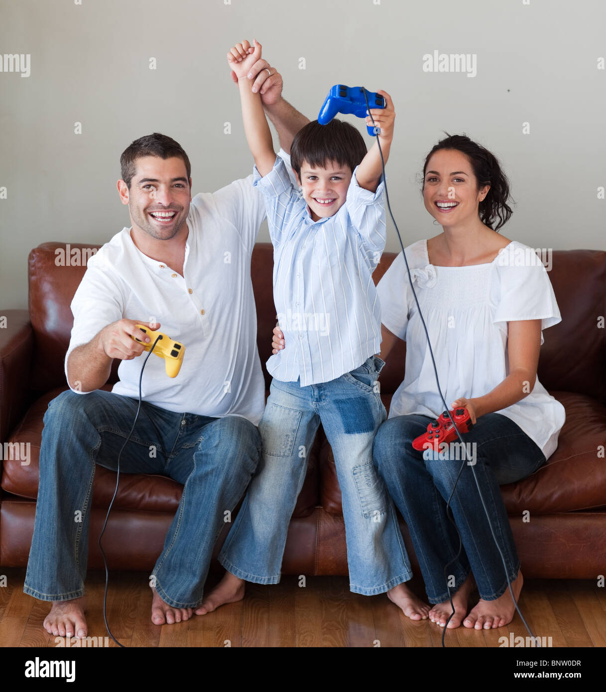 Smiling family playing video games in the living-room Stock Photo - Alamy