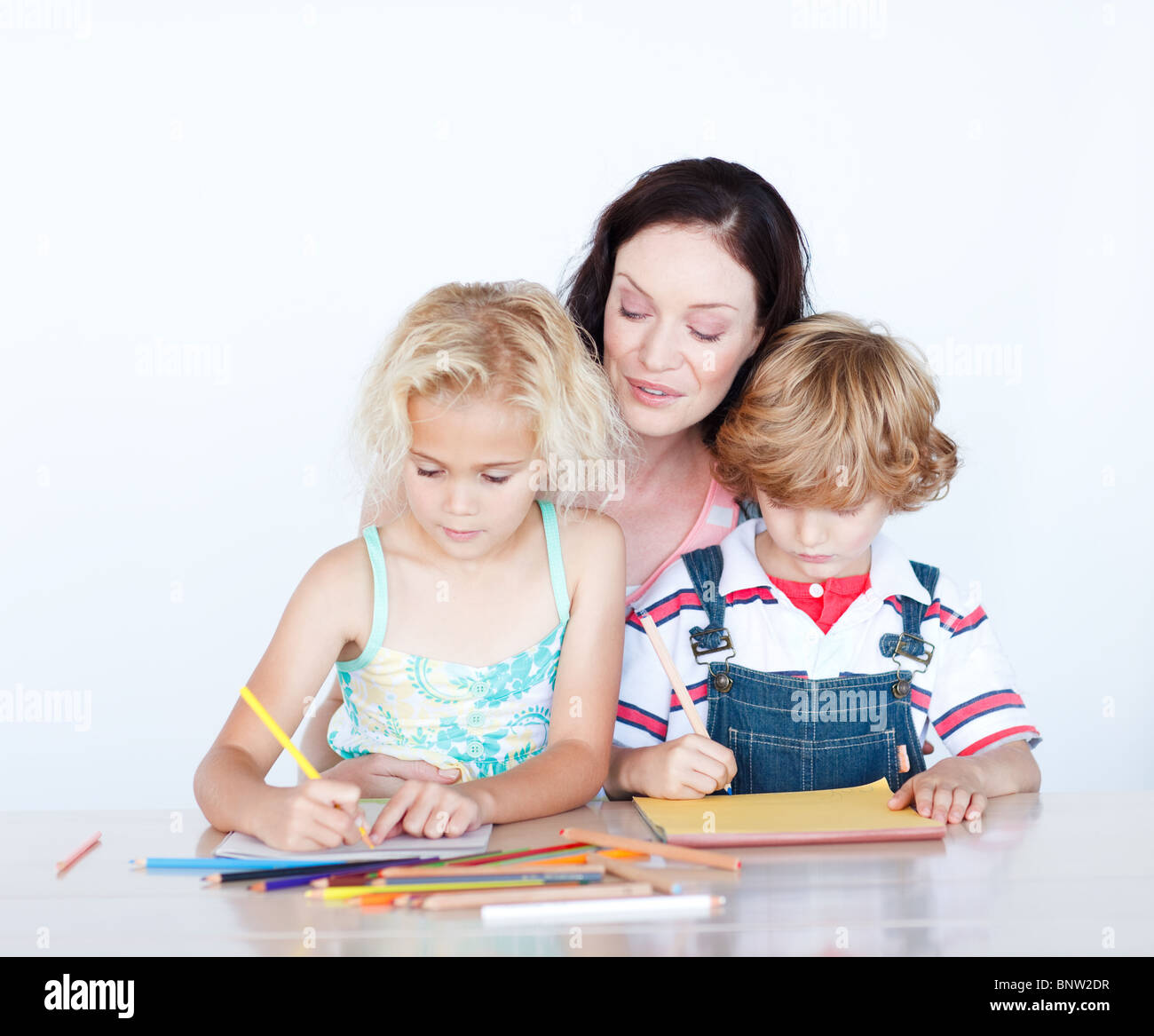 Mother and children writing together Stock Photo - Alamy