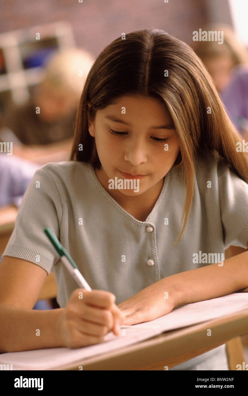 Elementary school student writing at her desk Stock Photo - Alamy
