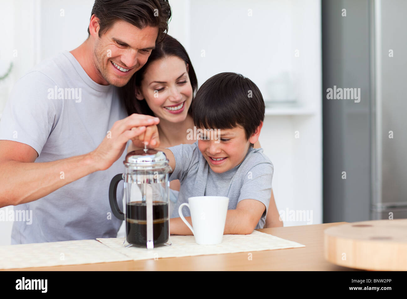 Smiling family preparing coffee Stock Photo - Alamy