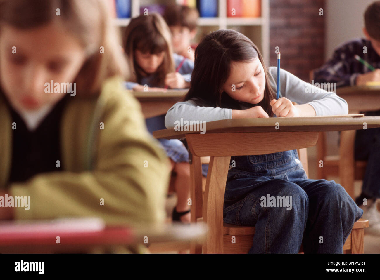 Elementary school students writing at their desk Stock Photo - Alamy