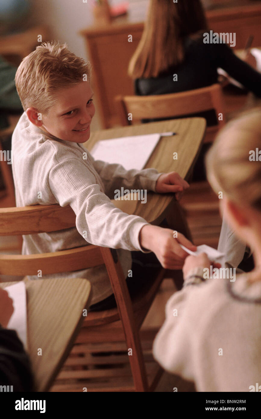 Students passing a note in classroom Stock Photo - Alamy