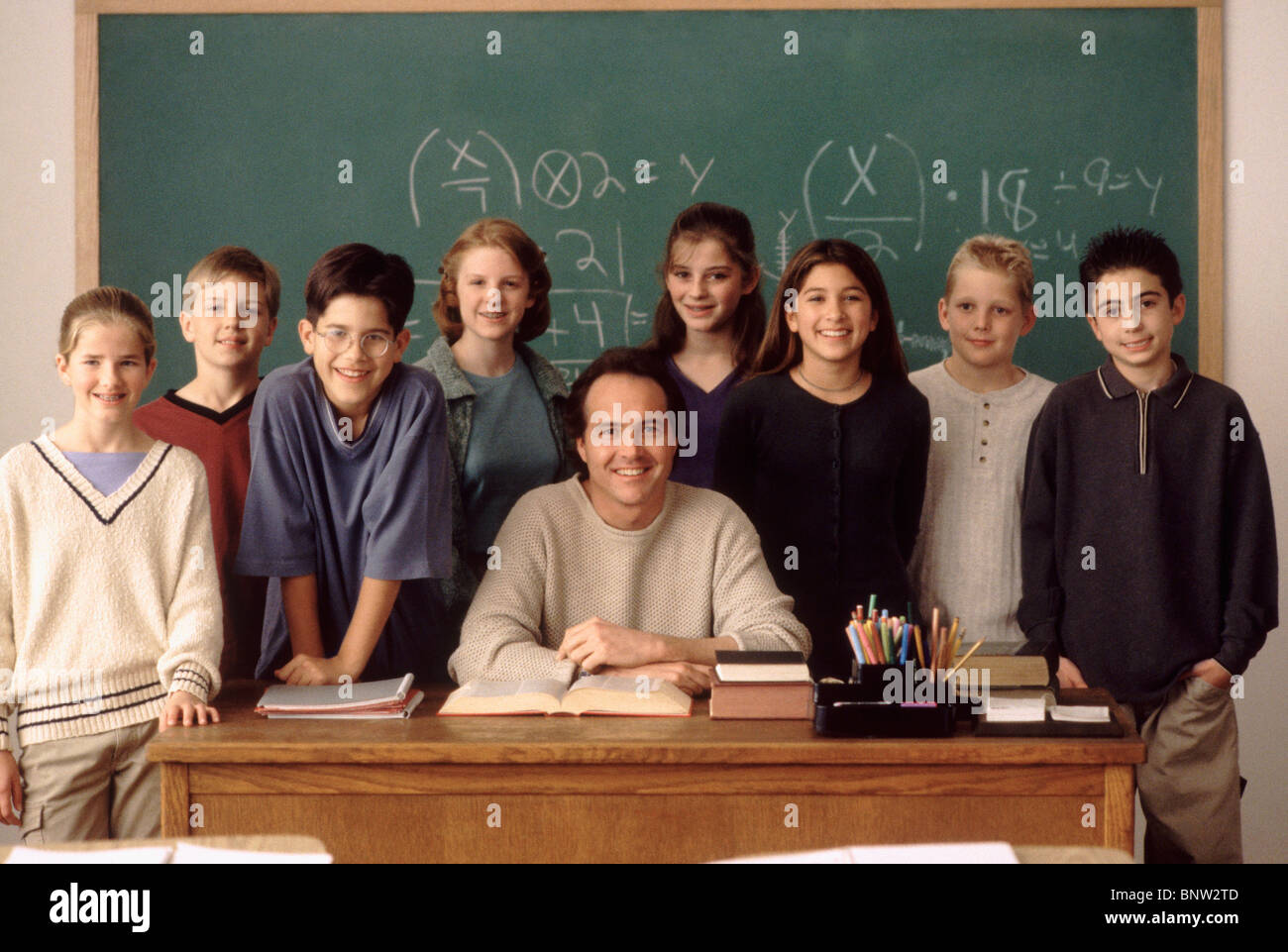 Elementary school students standing behind teacher Stock Photo - Alamy