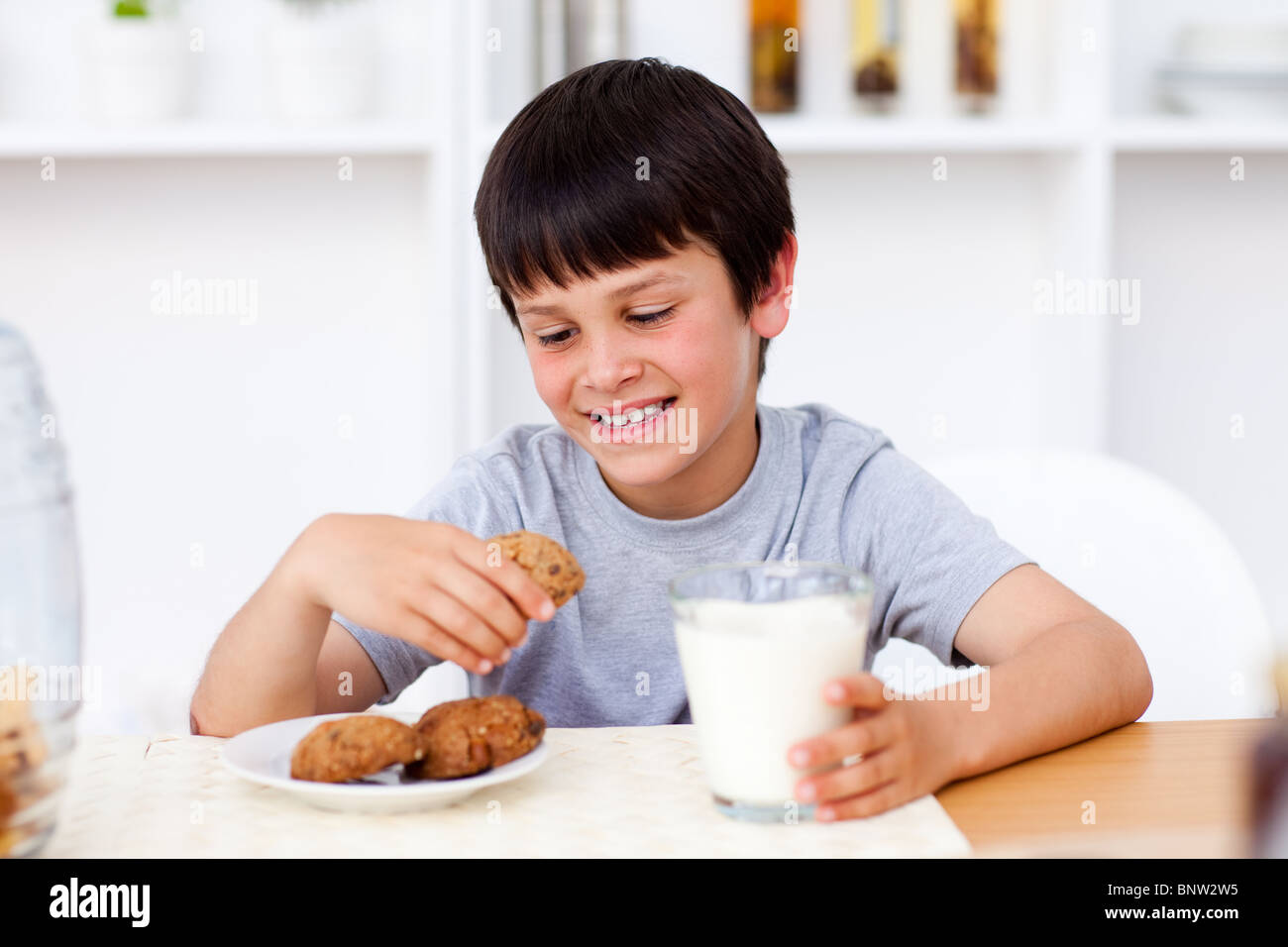 Portrait of a cute boy eating biscuits Stock Photo - Alamy
