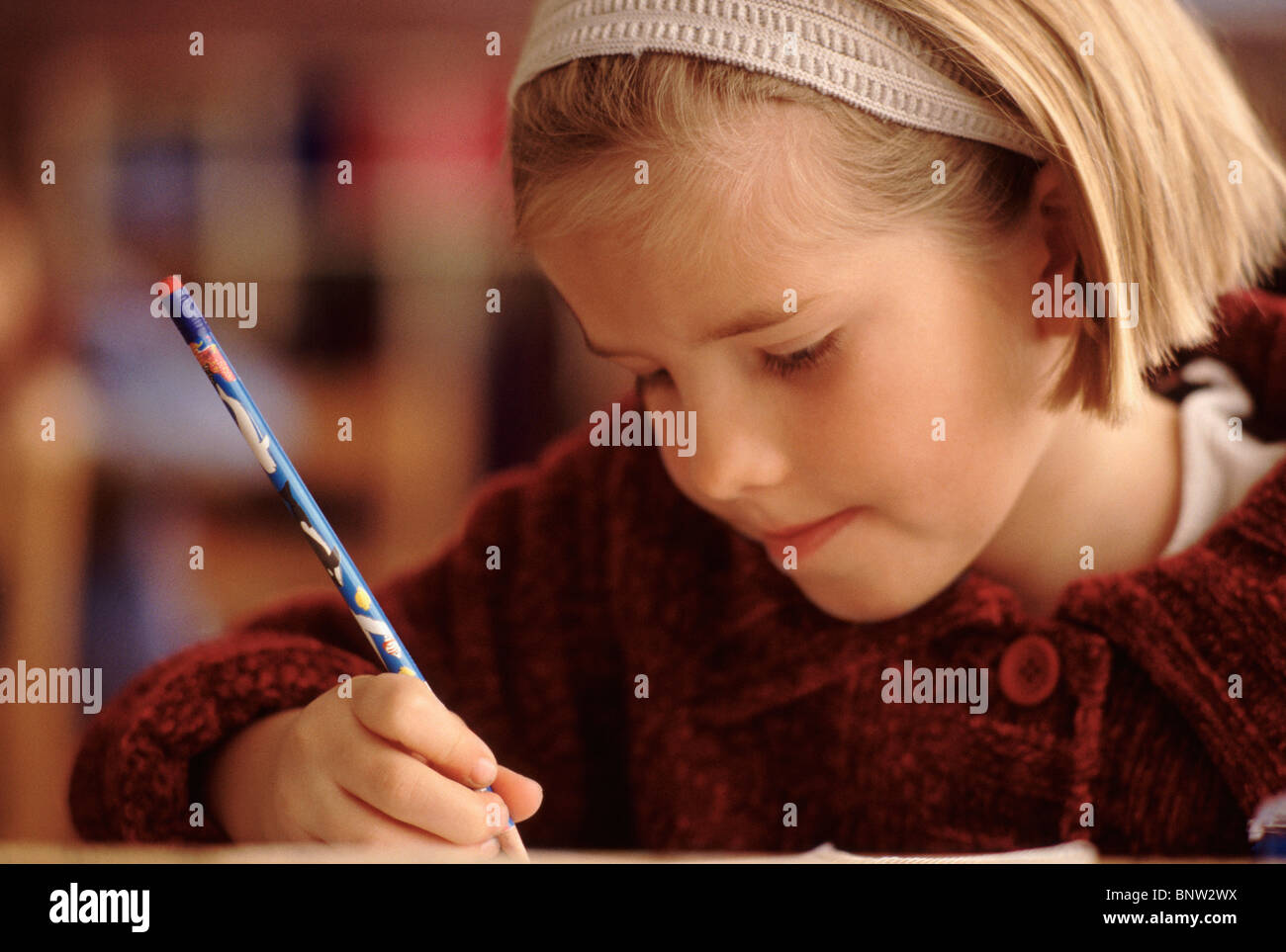 Elementary school student writing with a pencil Stock Photo - Alamy