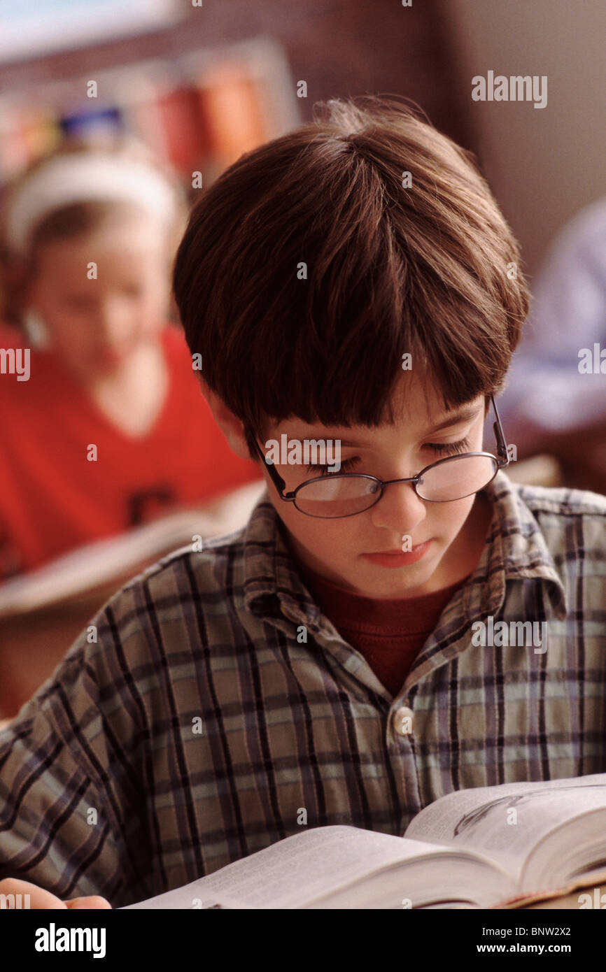 Elementary school student reading at his desk Stock Photo - Alamy
