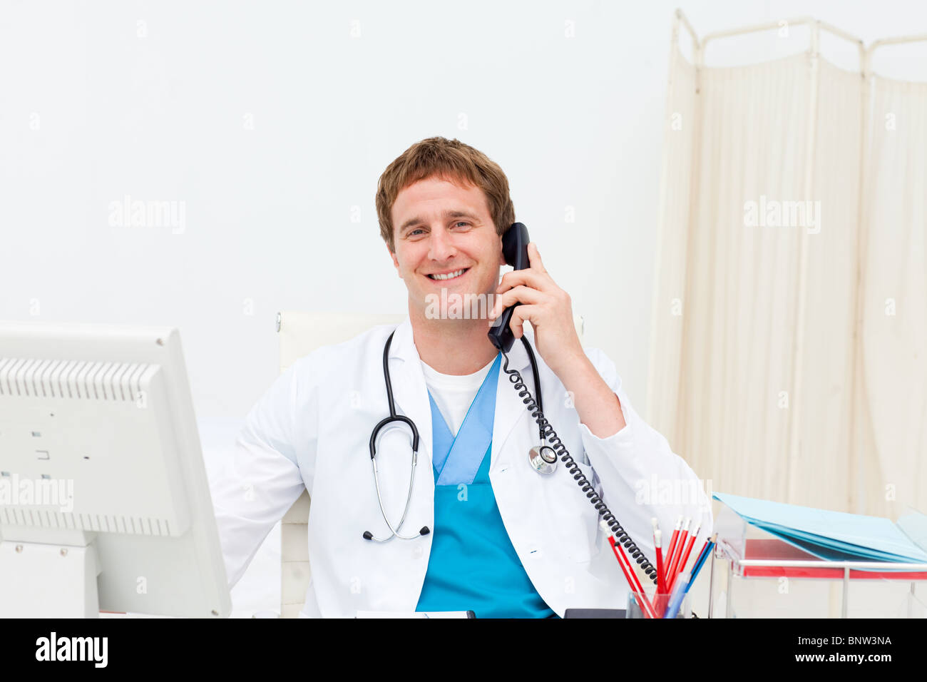 A doctor on phone smiling at the camera Stock Photo - Alamy