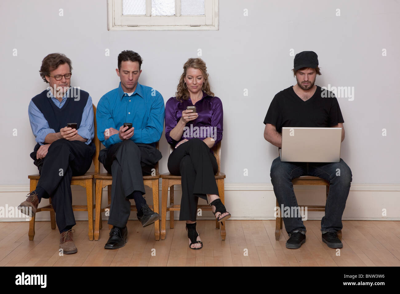 four people sitting in a row Stock Photo - Alamy