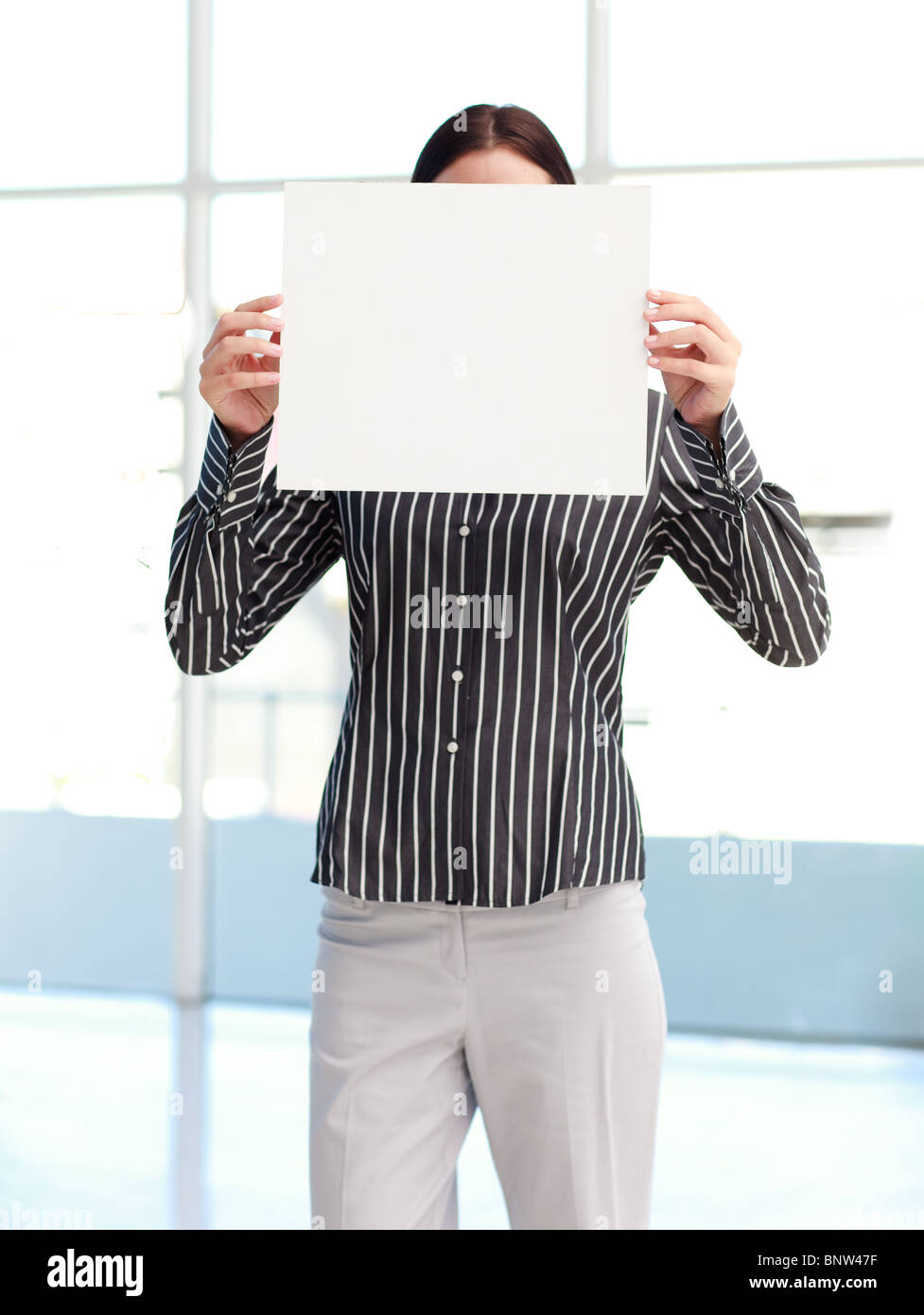 Businesswoman showing a white card in front of her face Stock Photo - Alamy