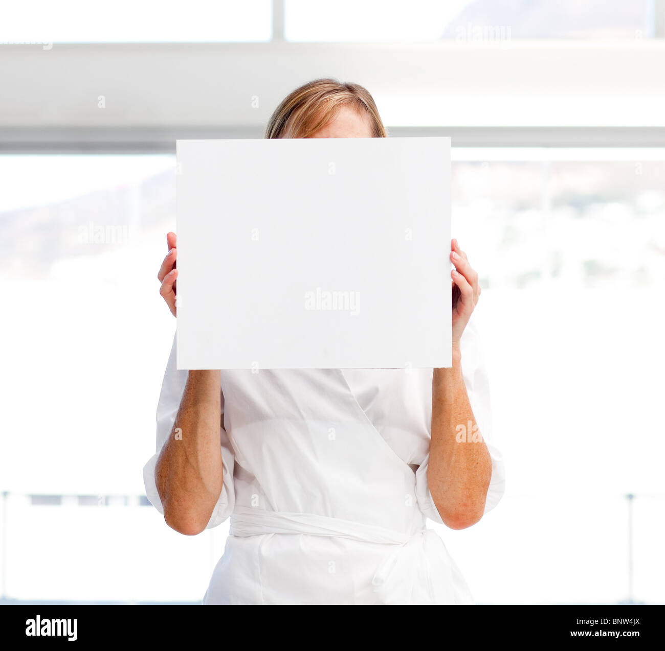 Businesswoman showing a white card in front of her face Stock Photo - Alamy