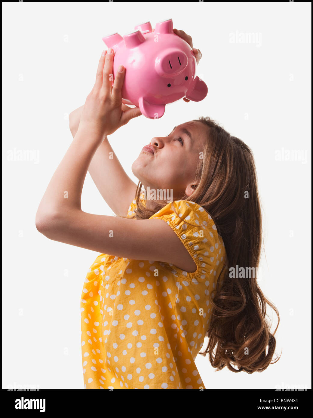 Teenage girl trying to get money out of piggy bank Stock Photo - Alamy