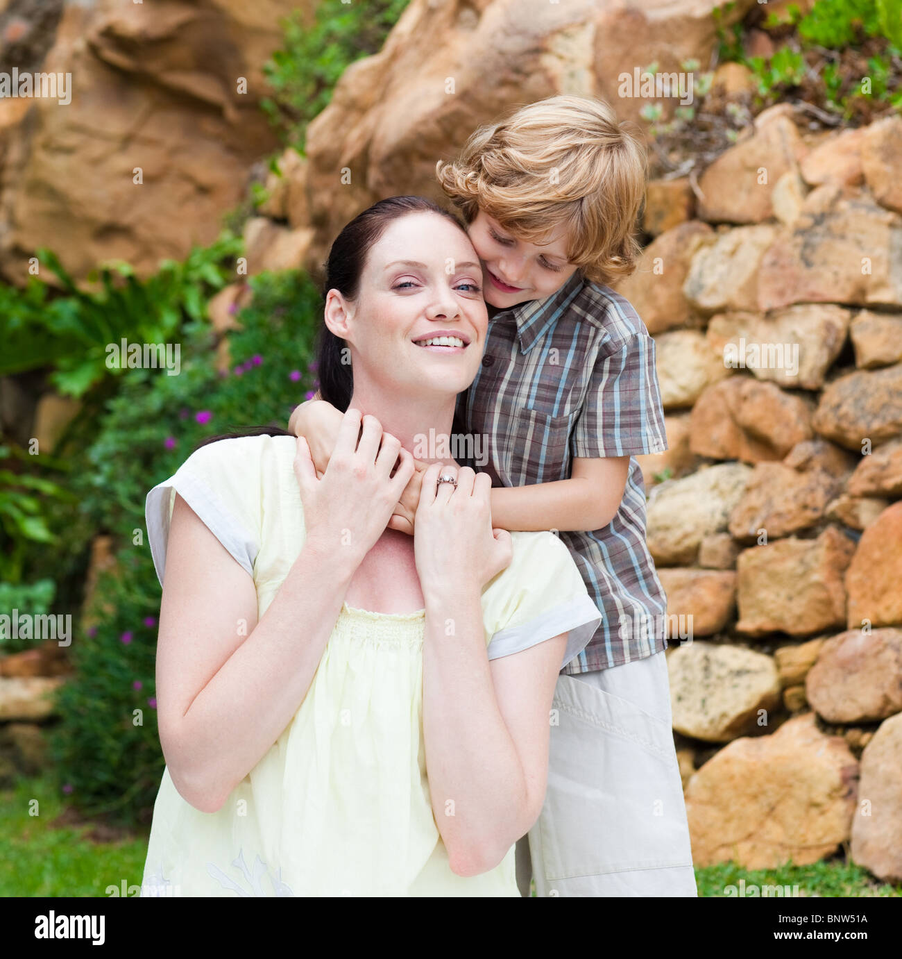 Son hugging his mother in a park Stock Photo - Alamy