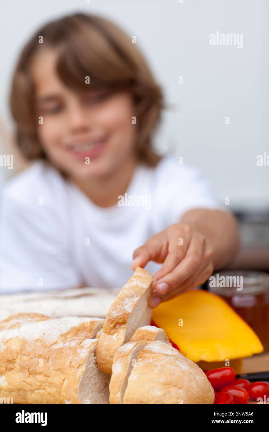 Smiling child taking a piece of bread Stock Photo - Alamy