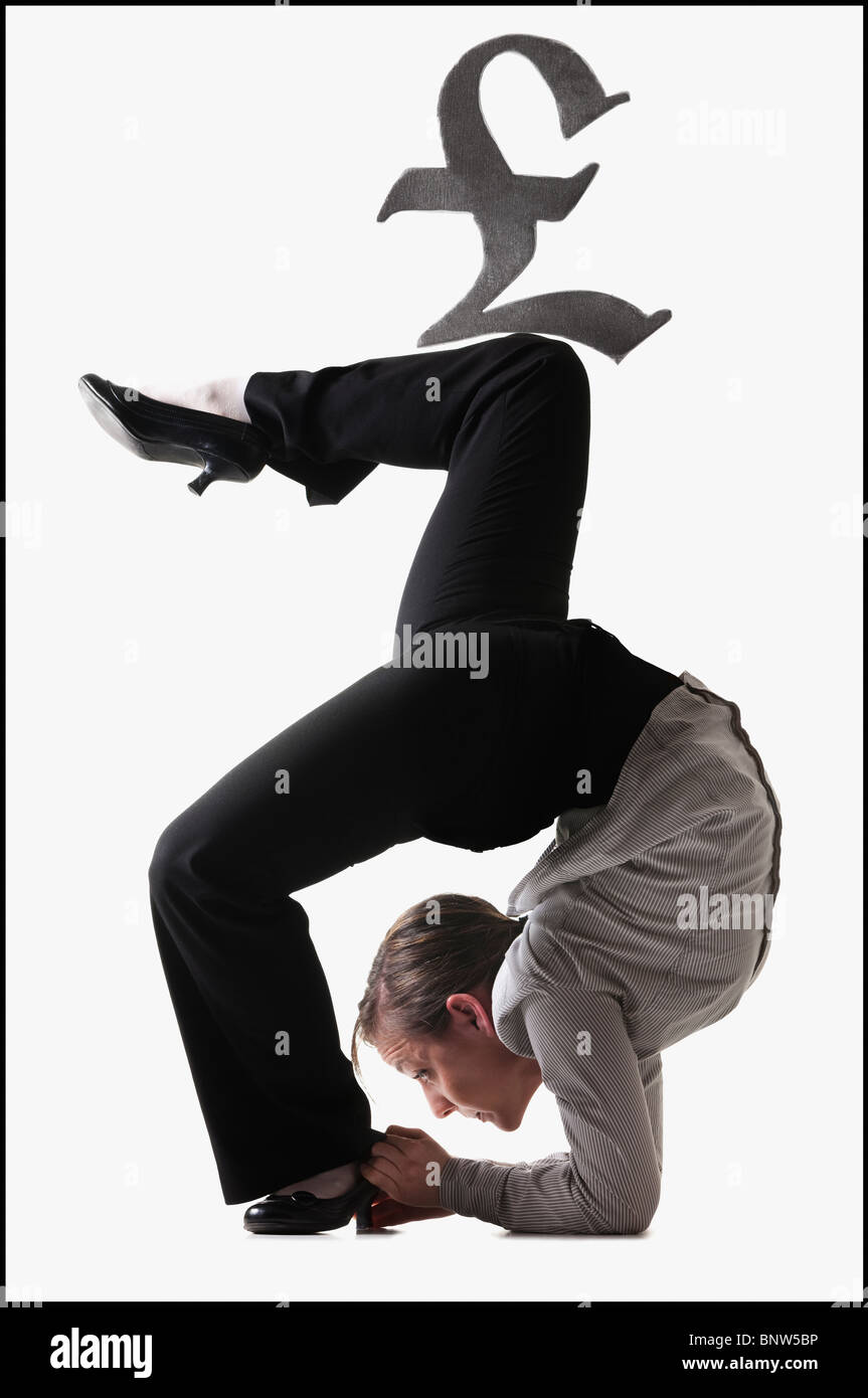 Pound symbol on top of contorted businesswoman Stock Photo - Alamy