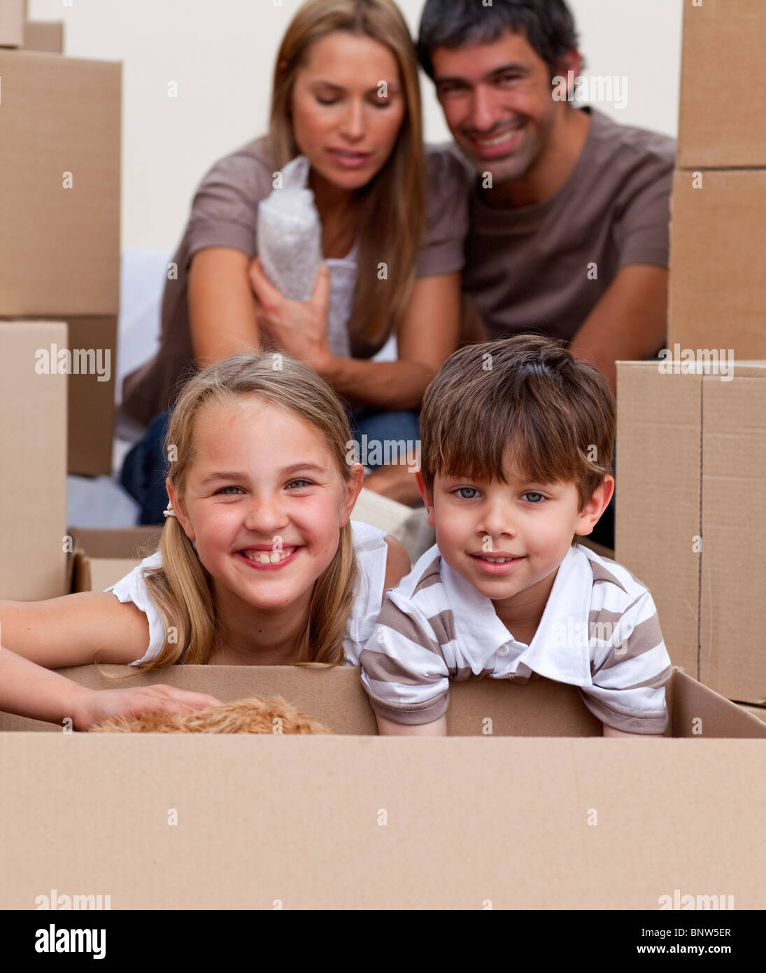 Portrait of children unpacking boxes with their parents Stock Photo - Alamy