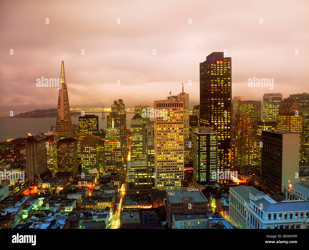 Office building lights with TransAmerica Pyramid and Oakland Bay Bridge ...