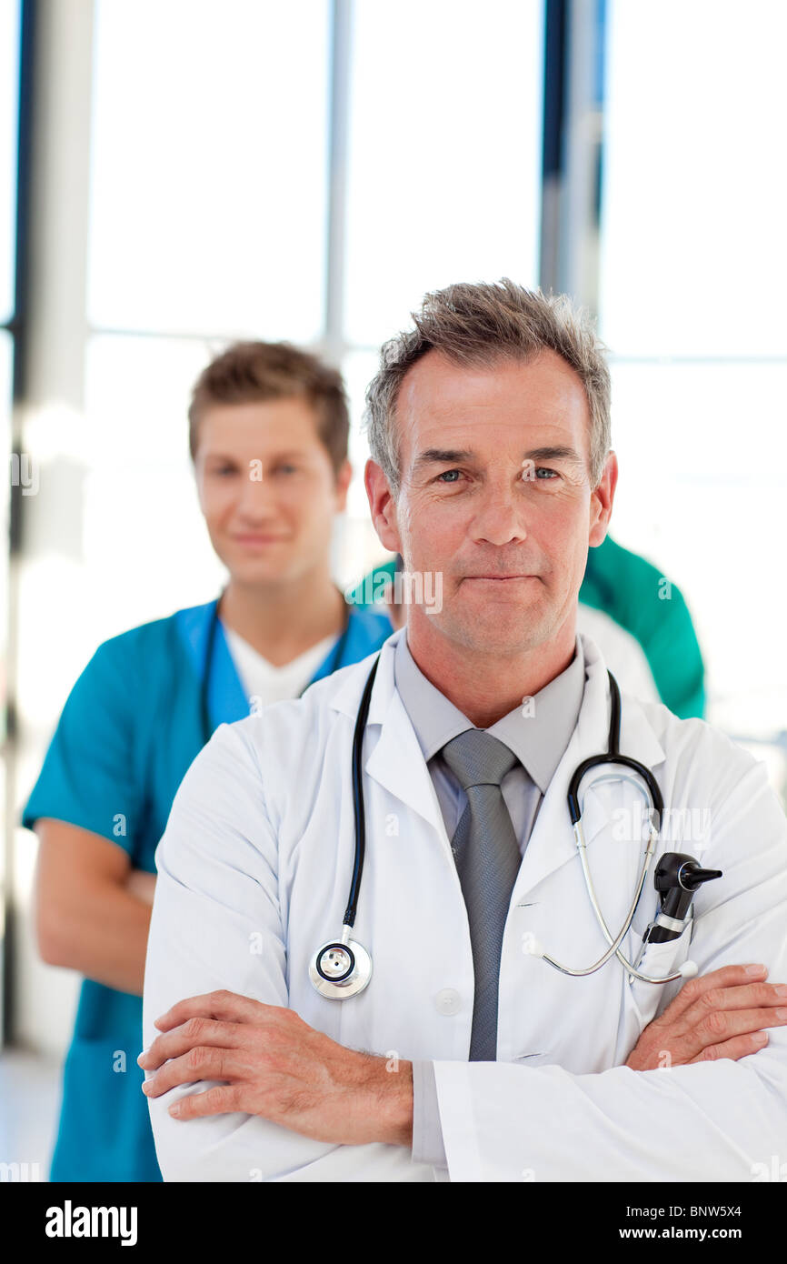 Friendly mature doctor leading his team Stock Photo - Alamy
