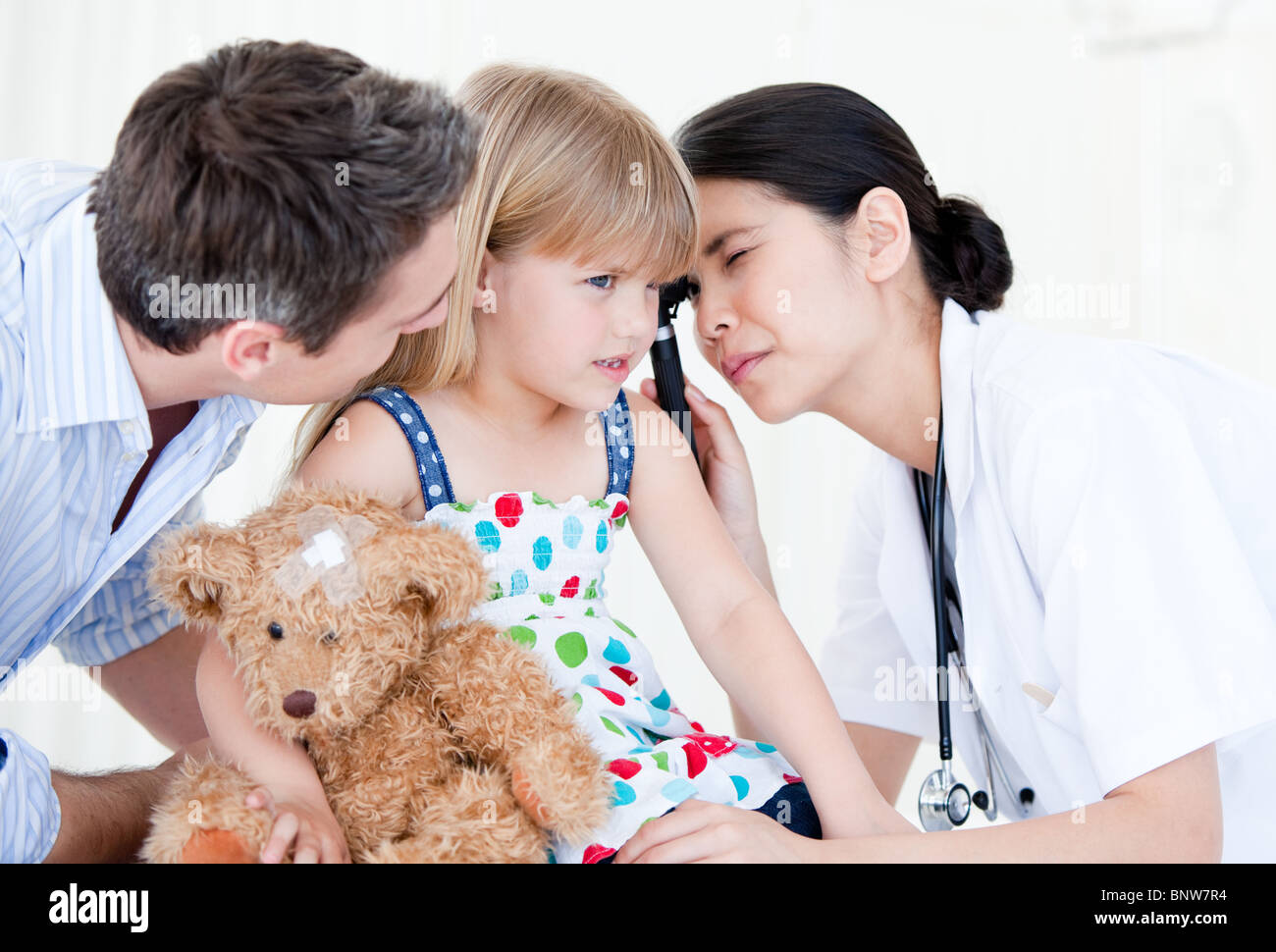 Radiant female doctor examining little girl with medical equipment ...