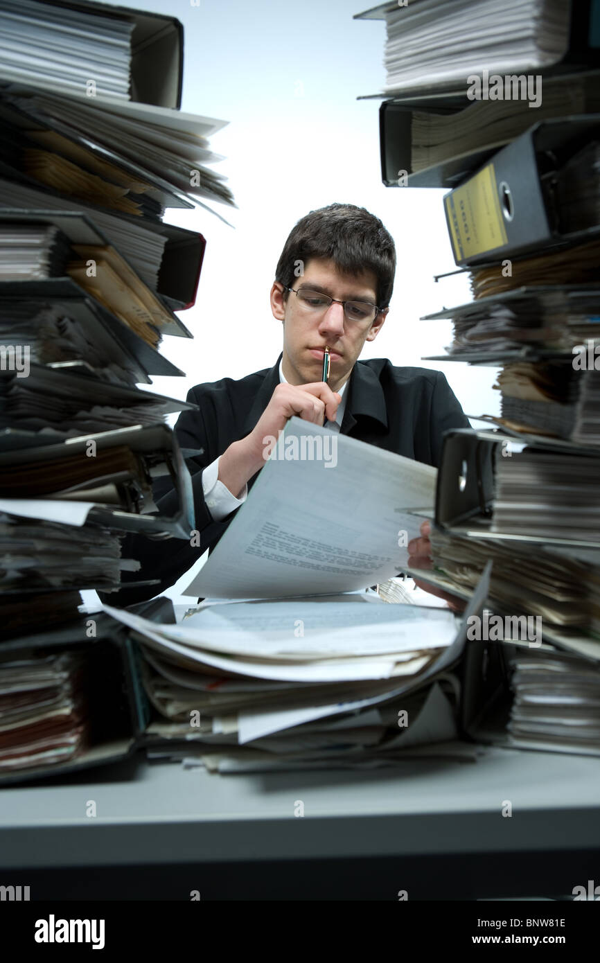 Overworked bookkeeper at his desk Stock Photo - Alamy