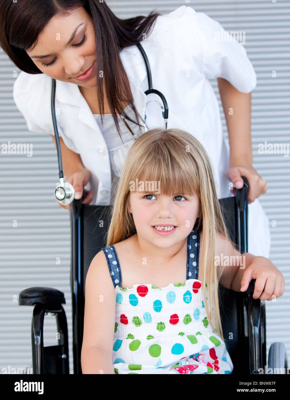Smiling cute girl sitting on the wheelchair Stock Photo - Alamy