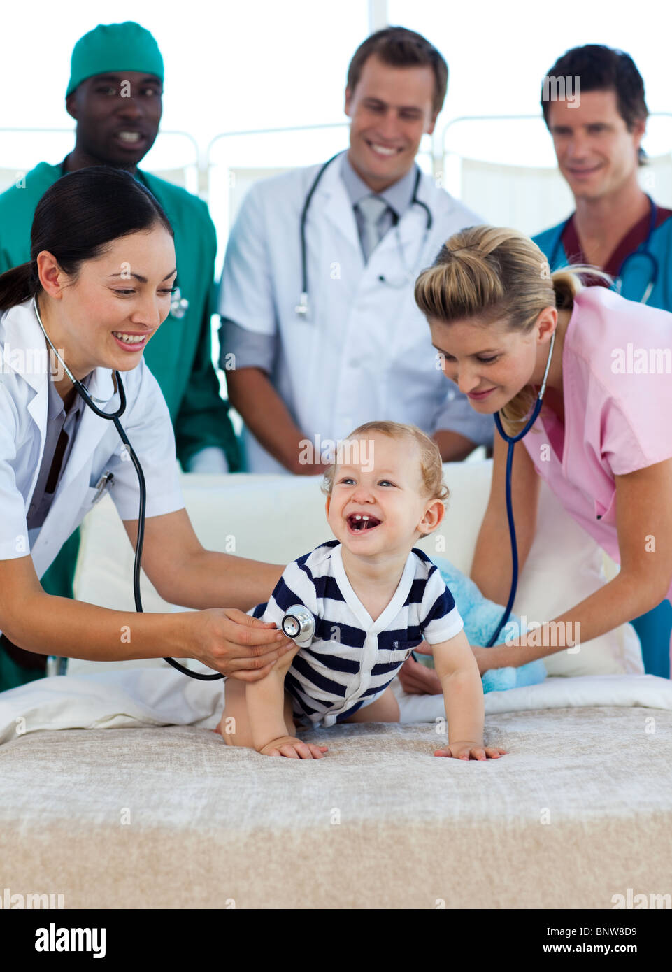 Smiling baby with a medical team in hospital Stock Photo - Alamy