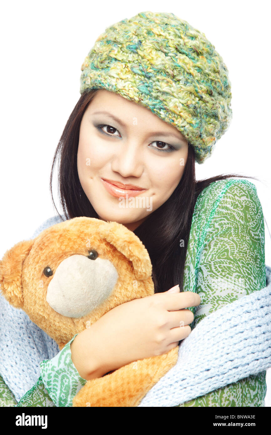 Smiling lady in the stylish winter clothes and cap holding Teddy bear ...
