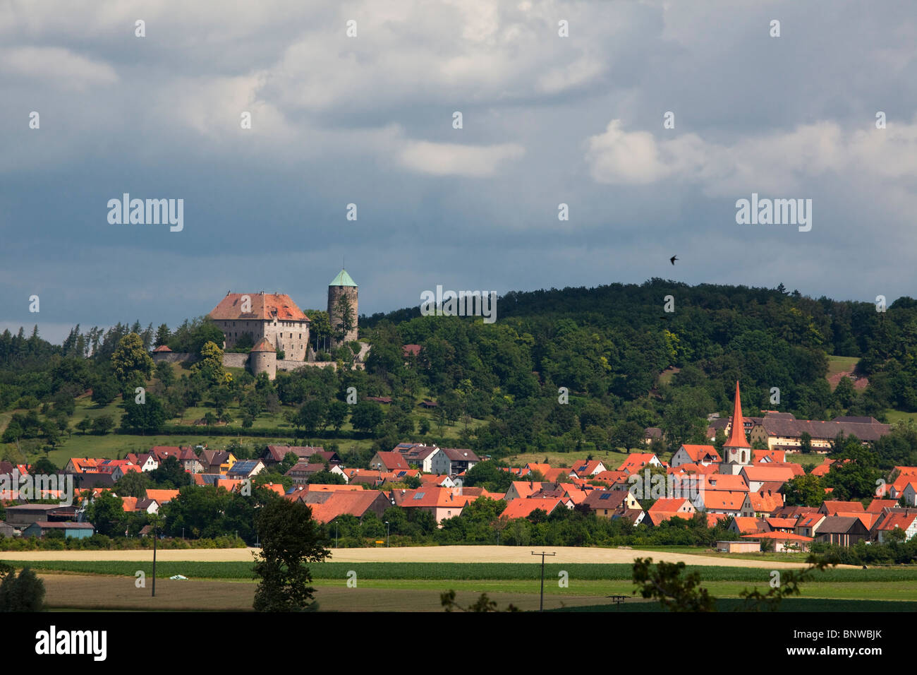 13th century Medieval Castle hotel Colmberg on hillside above quaint ...