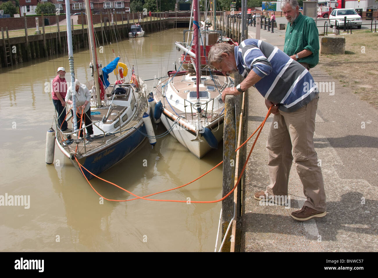 tied double berthed sailing boat sailors talking Stock Photo - Alamy