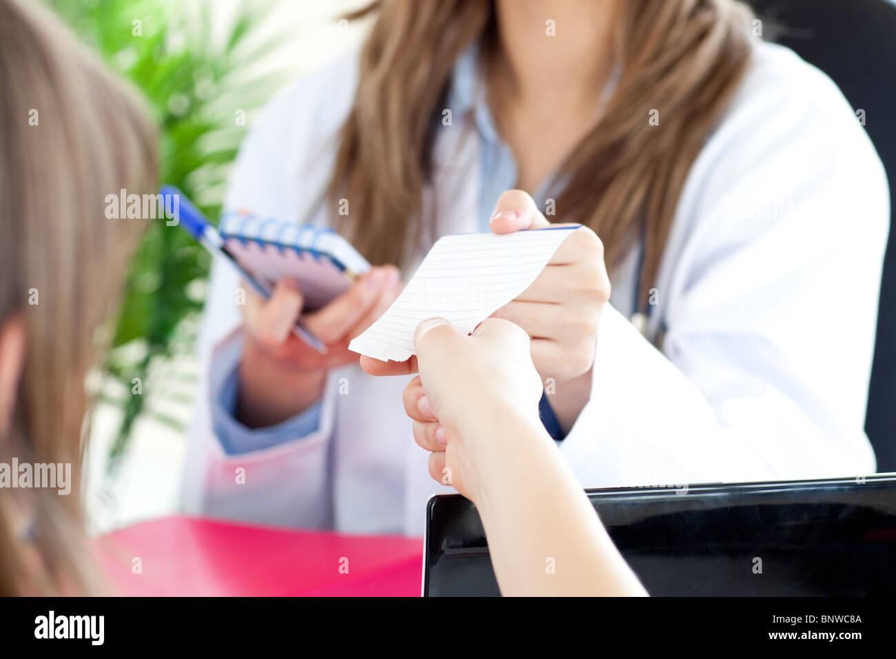 Radiant female doctor giving a paper to her patient Stock Photo - Alamy