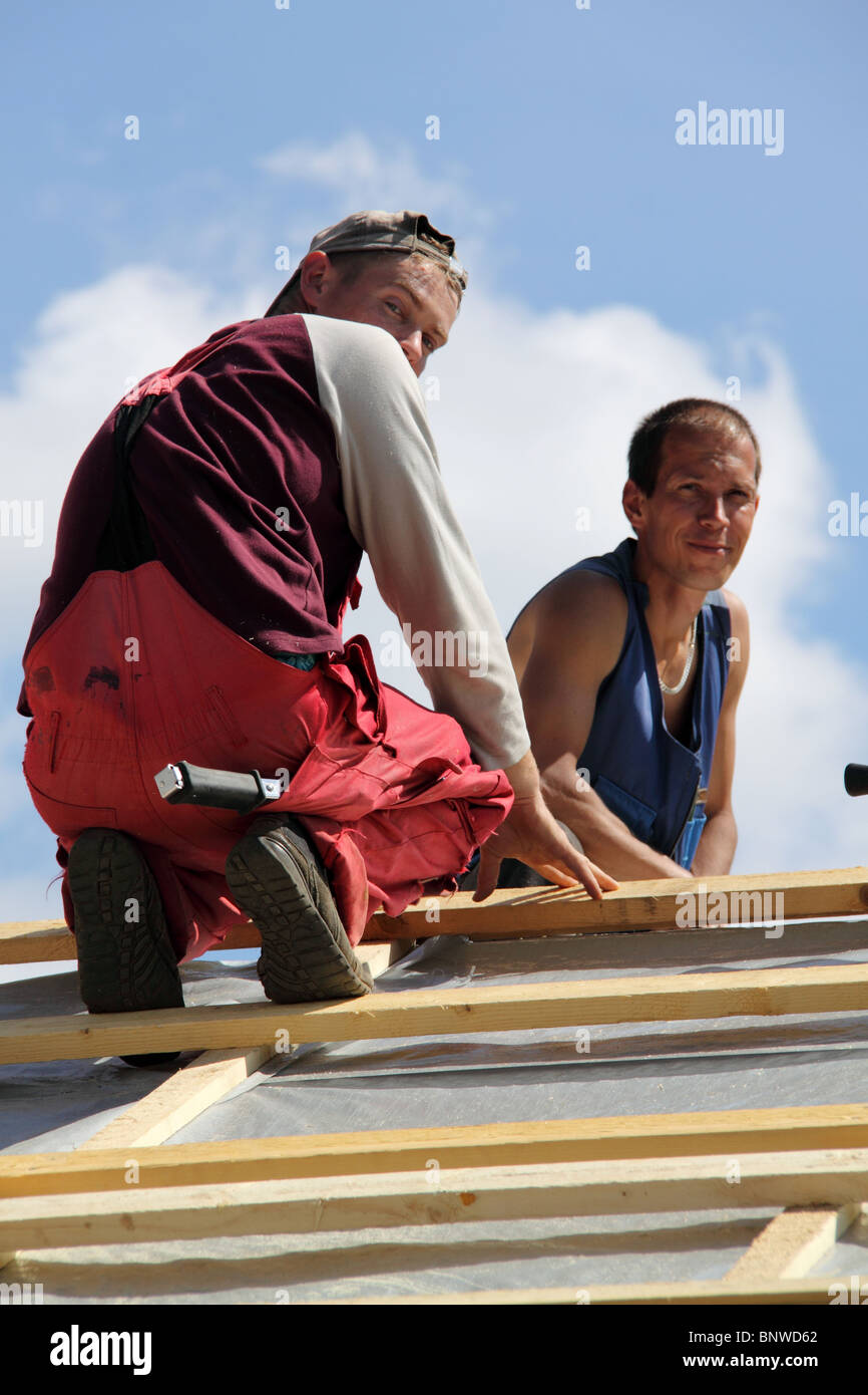 Two builders on roof Stock Photo - Alamy