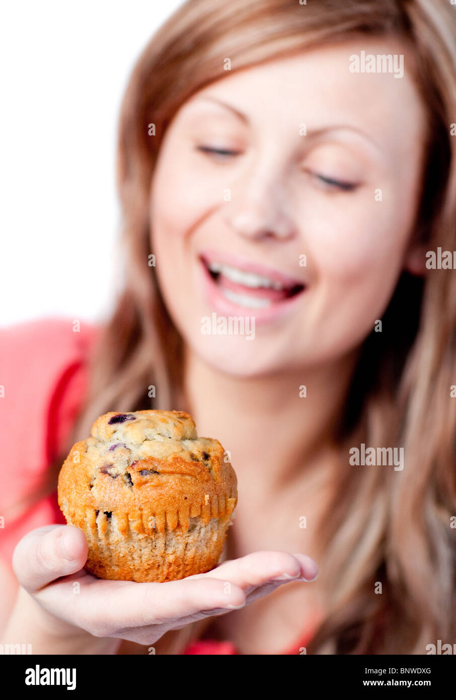 Radiant woman is eating a muffin Stock Photo - Alamy
