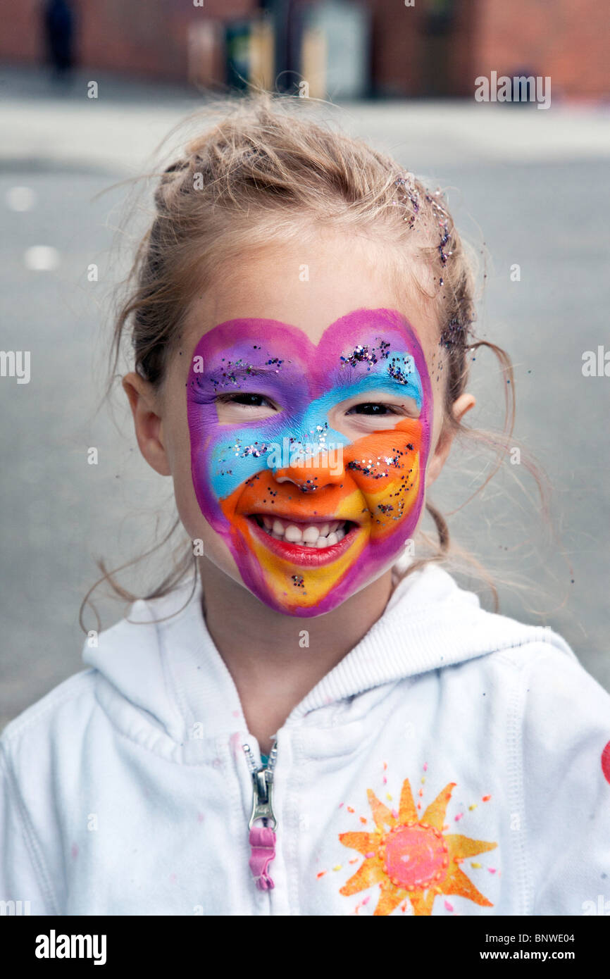 happy fair haired young girl with multicolored glittery heart painted ...