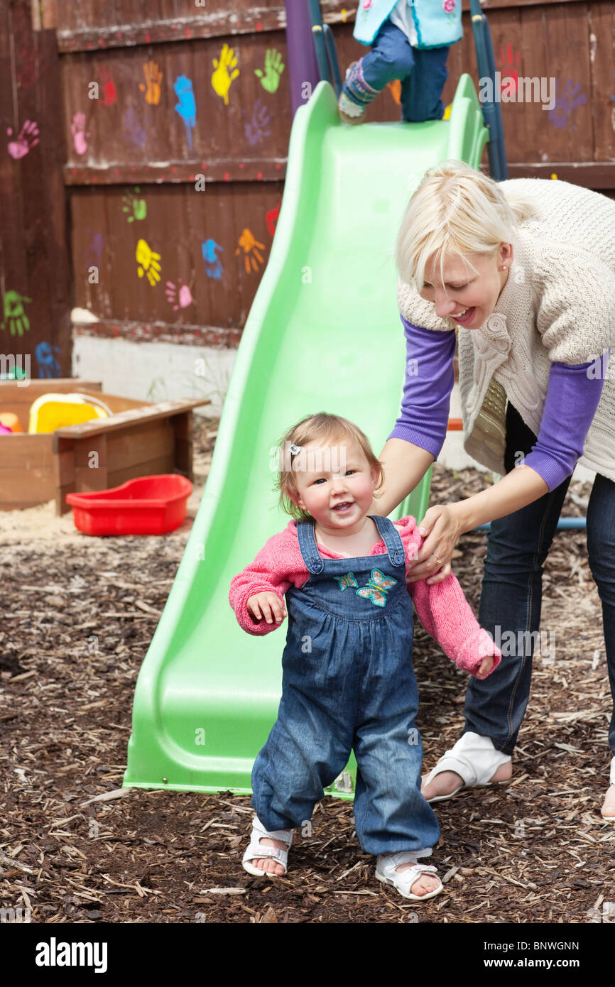 Little girl standing before a green chute Stock Photo - Alamy