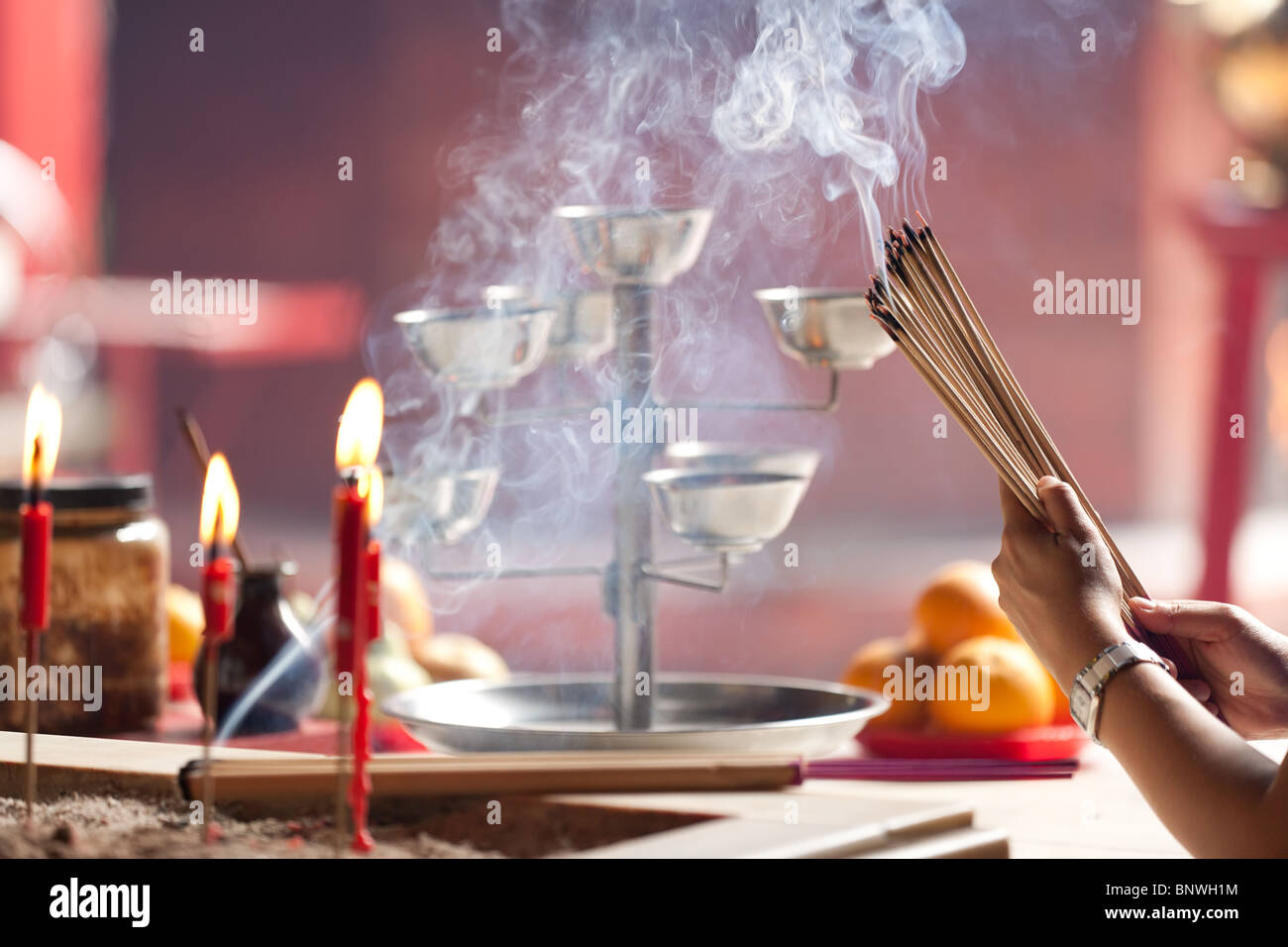 woman offering smoking incense in chinese temple, Kuala Lumpur ...