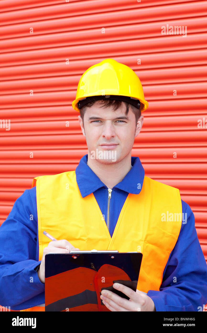 Confident worker writing on a clipboard Stock Photo - Alamy