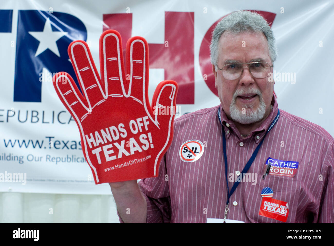 A vendor displays a foam hand that says "Hands off Texas", one of the ...