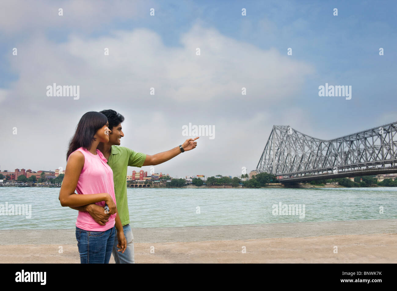 Couple standing with a bridge in the background, Howrah Bridge, Hooghly ...