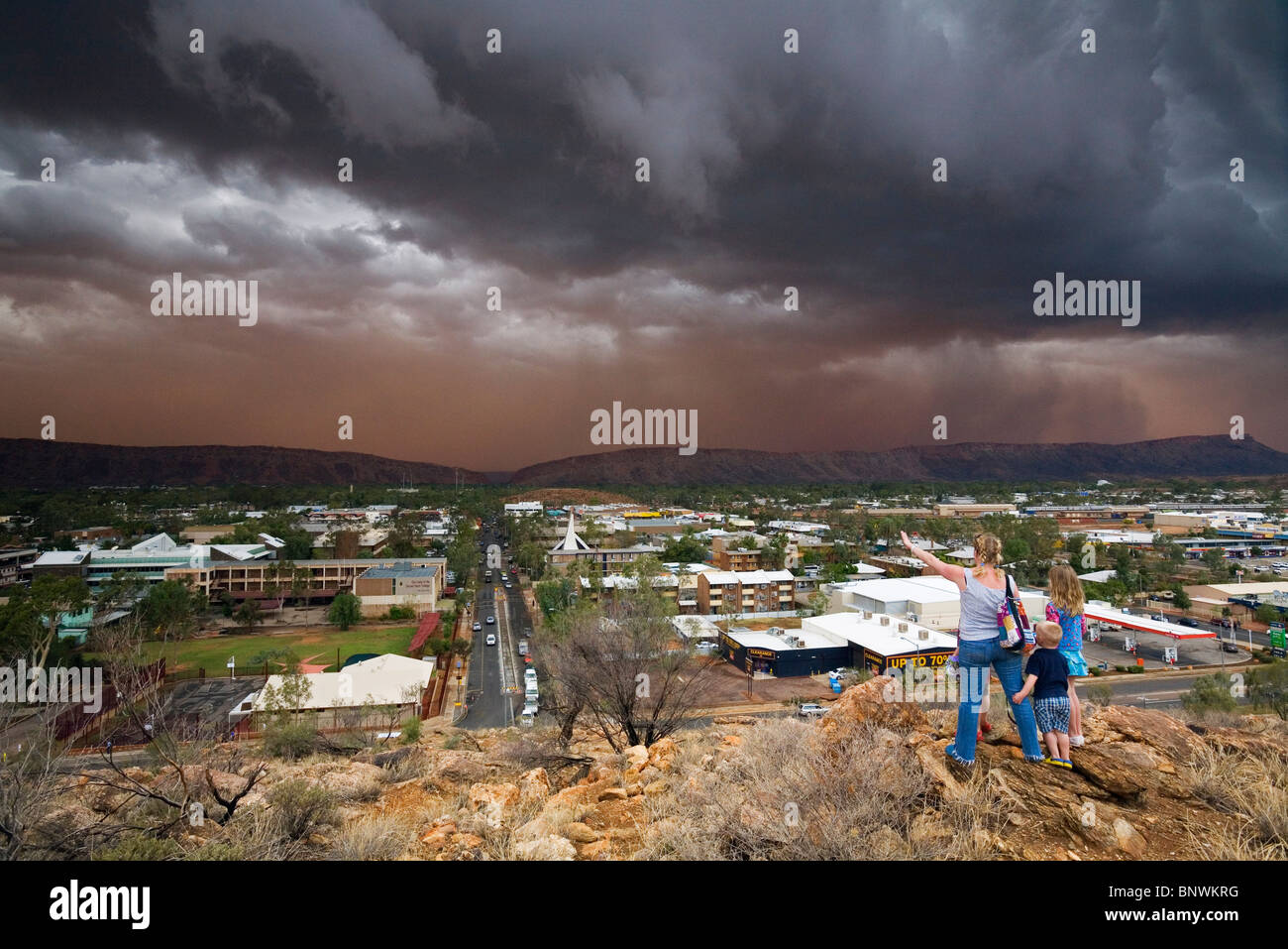 A young family looks out over Alice Springs as a dust storm approaches ...